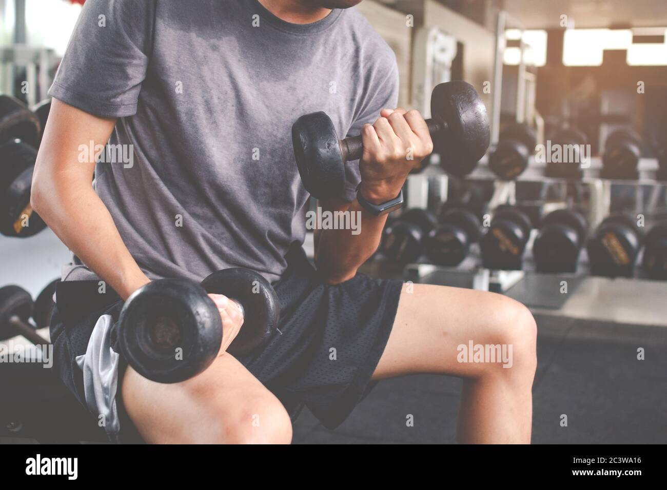 Closeup of a thin man doing exercises with dumbbell. Fitness muscular ...