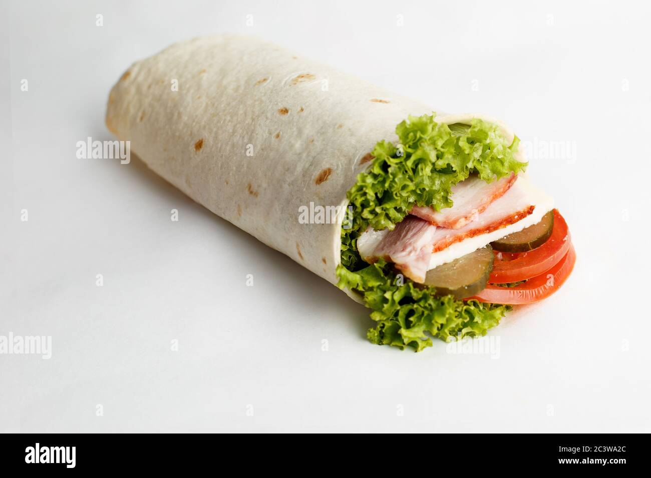 Hot roll with bacon, lettuce, cucumber and tomatoes. Close-up Stock ...