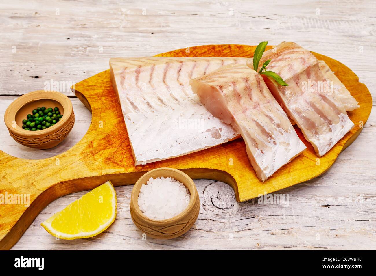 Raw hake fillet. Lemon, salt, spices. The concept of healthy eating ...