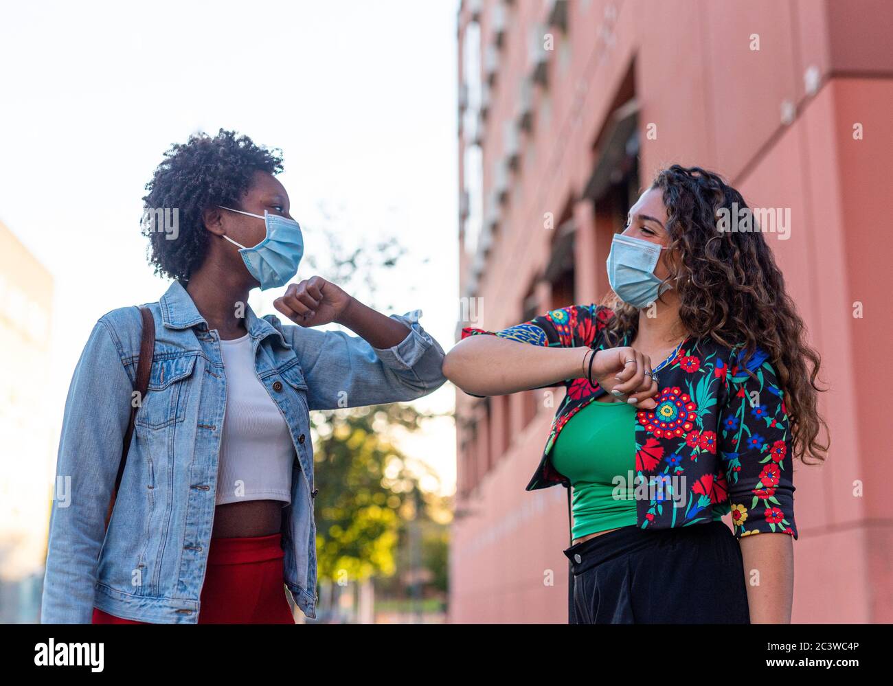 Young and friendly african girl and caucasian girl keeping social ...