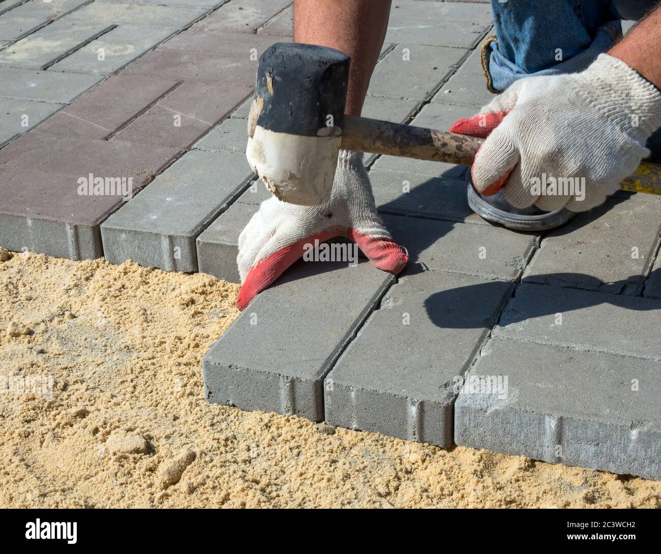 Installation of paving slabs on a sandy base Stock Photo - Alamy
