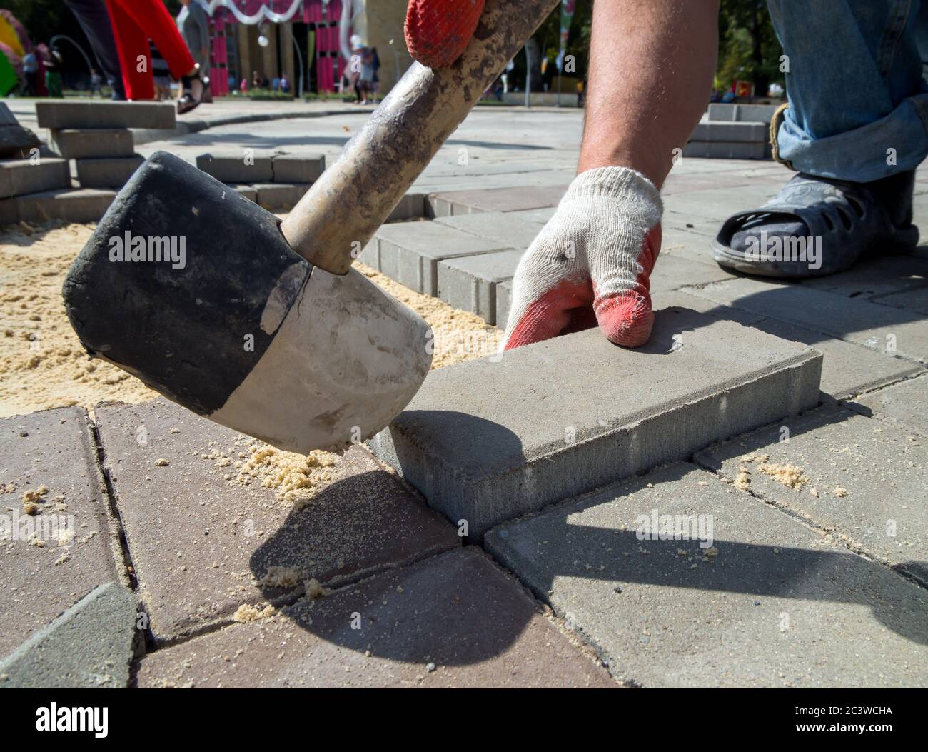 Worker puts paving stones with a mallet Stock Photo - Alamy
