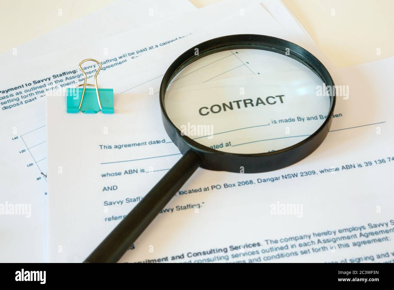 On the table is a contract form. Magnifier approximates the word ...