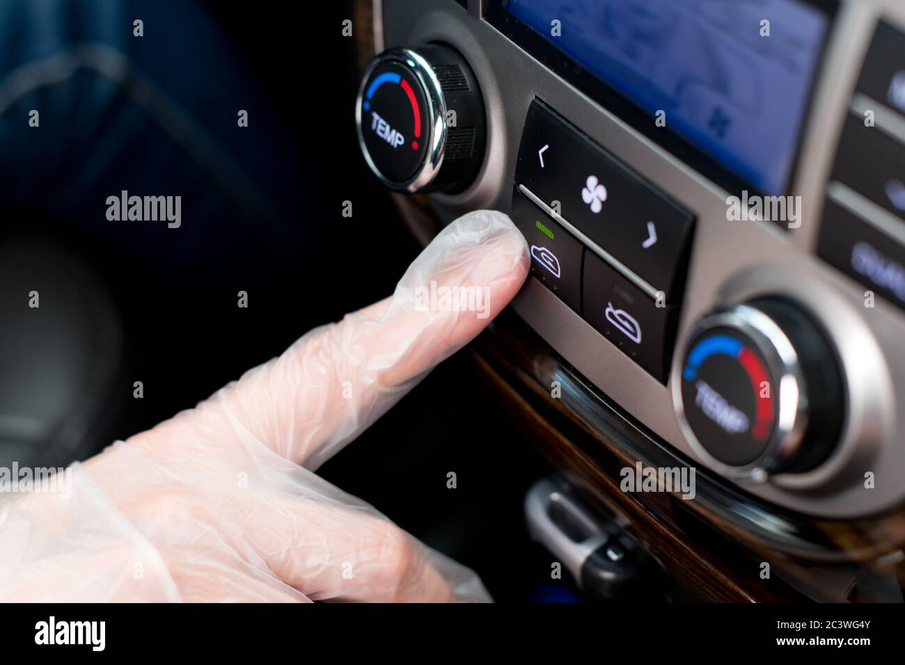 a hand in a medical glove presses the air recirculation button in the ...