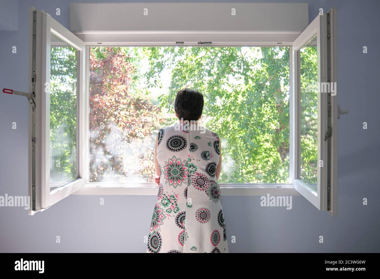 Old lady looking through window hi-res stock photography and images - Alamy