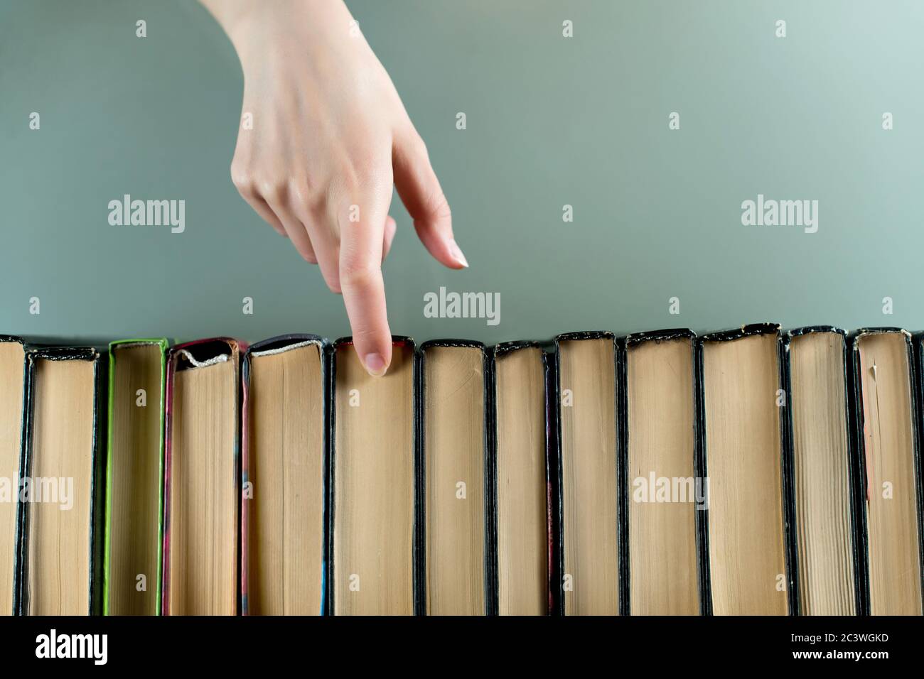 Female hand selects a book to read, top view Stock Photo - Alamy