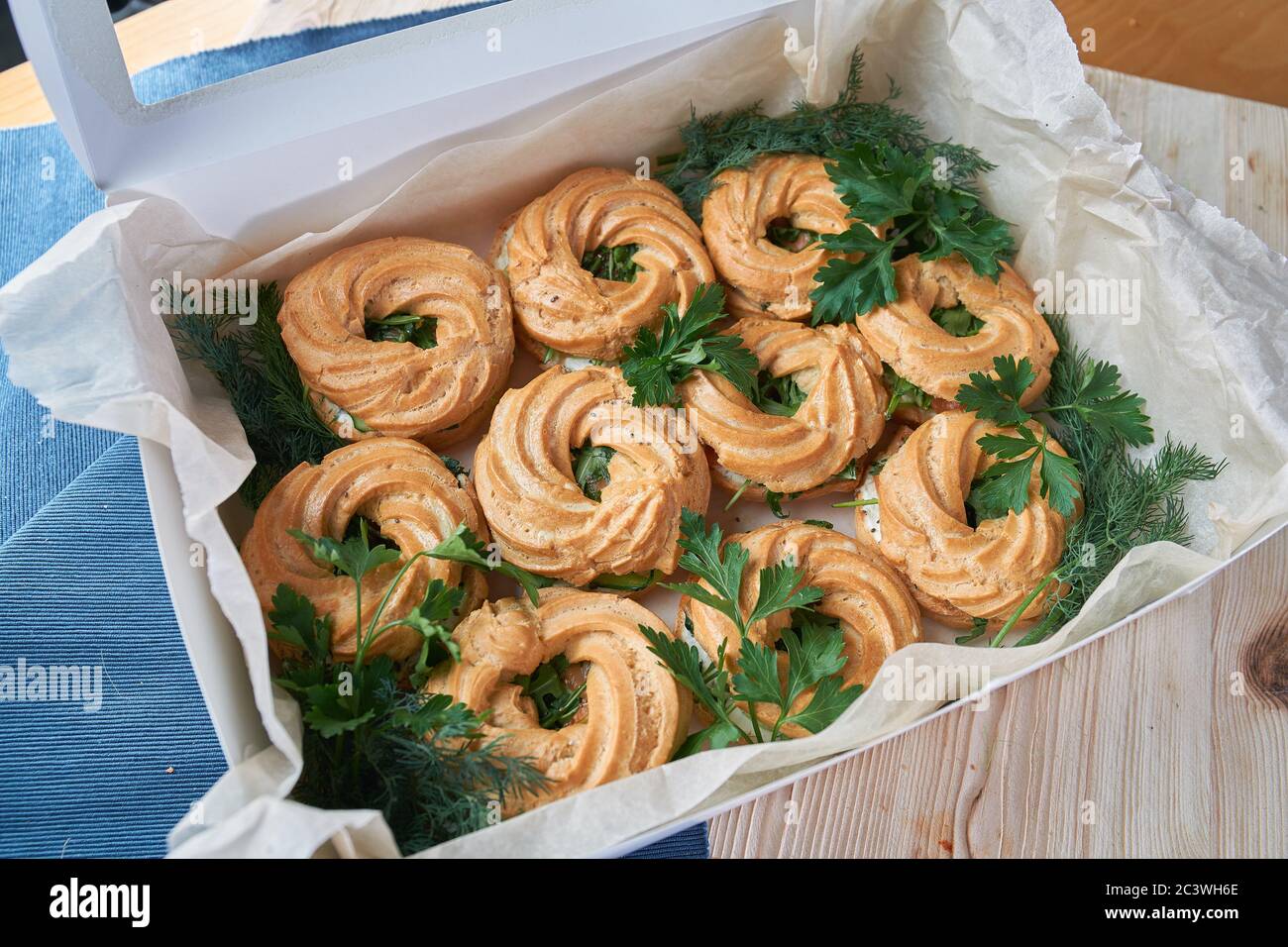 Round bagels with cucumber and herbs in a white box. Close-up. light ...