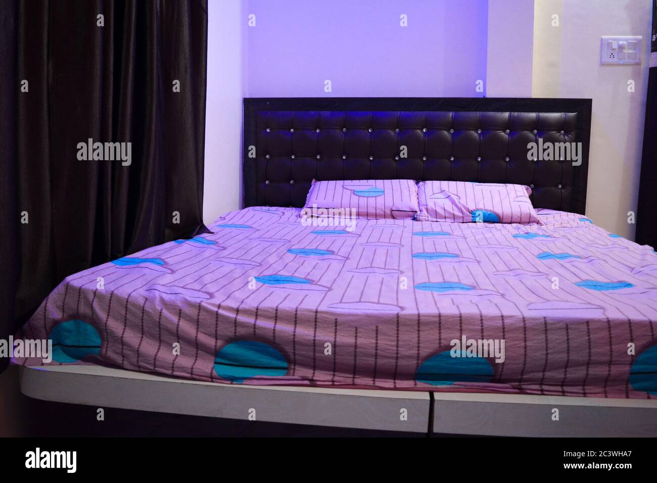 Simple bedroom with comfortable soft bed Stock Photo - Alamy