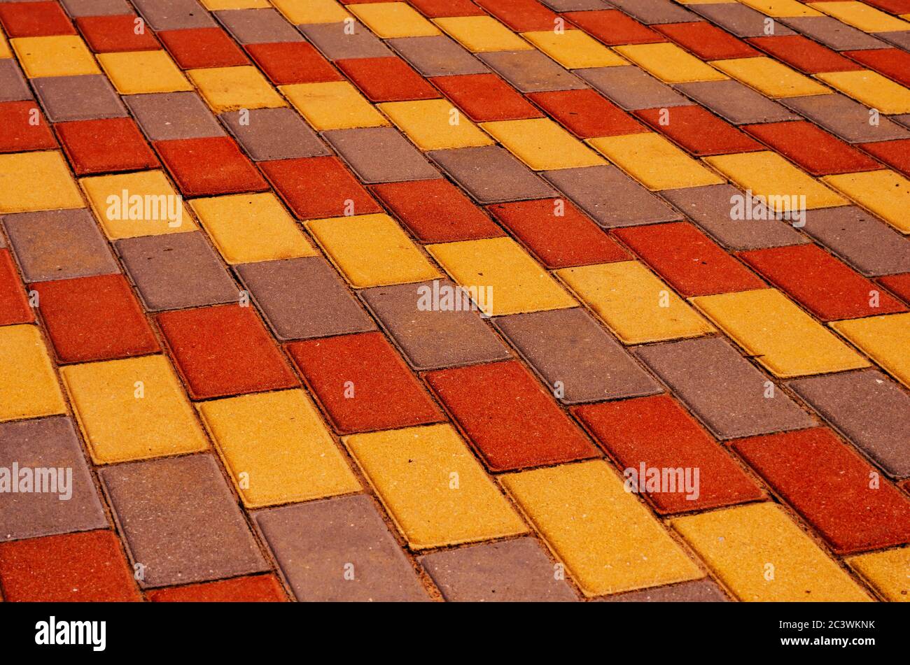 City street paved with three-color paving slabs. Sidewalk with gray ...