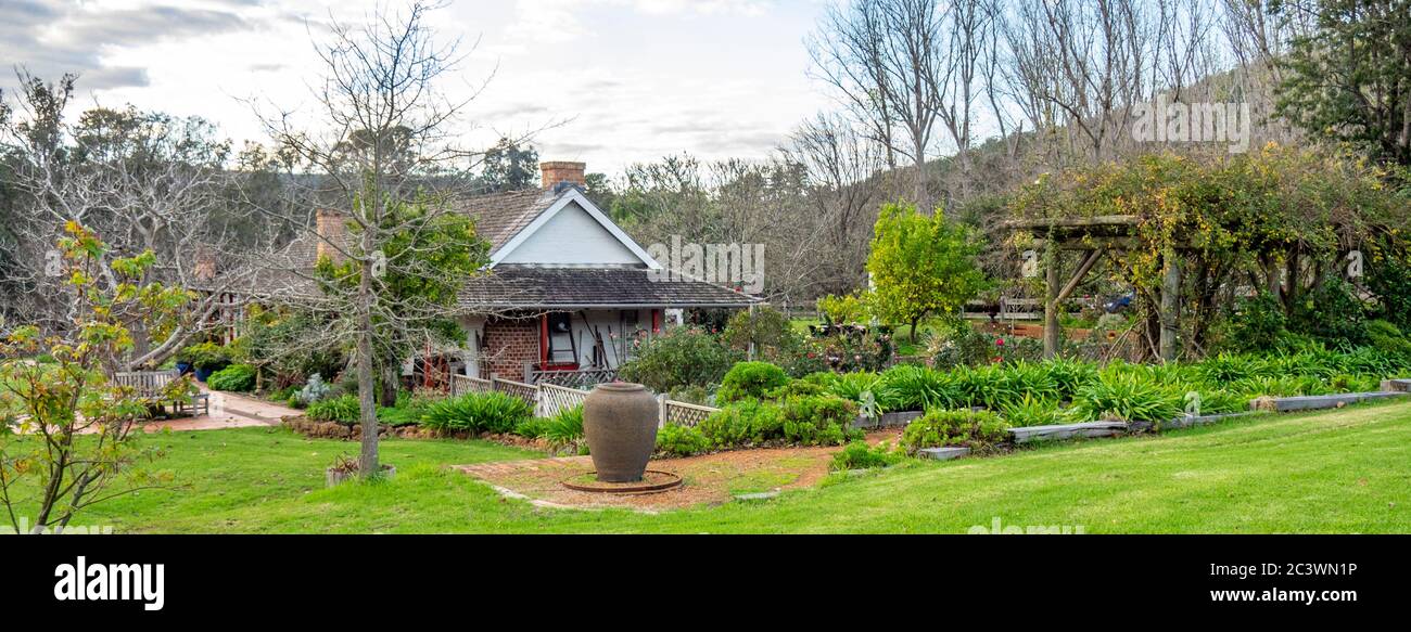 Rustic heritage farmhouse with a large terracotta urn in yard Western ...