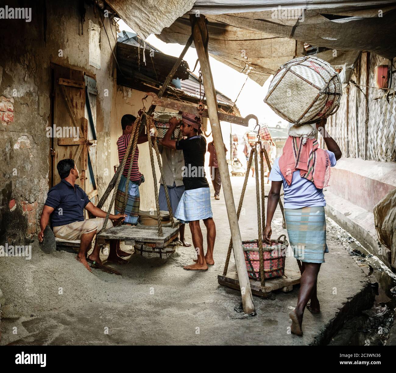 Chittagong, Bangladesh, December 22, 2017: Men weighing baskets with ...