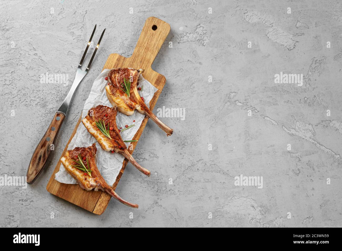 Grilled rack of lamb served on a wooden board Stock Photo - Alamy