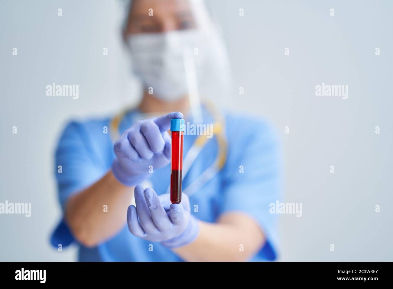 Doctor holding blood sample over light background Stock Photo - Alamy