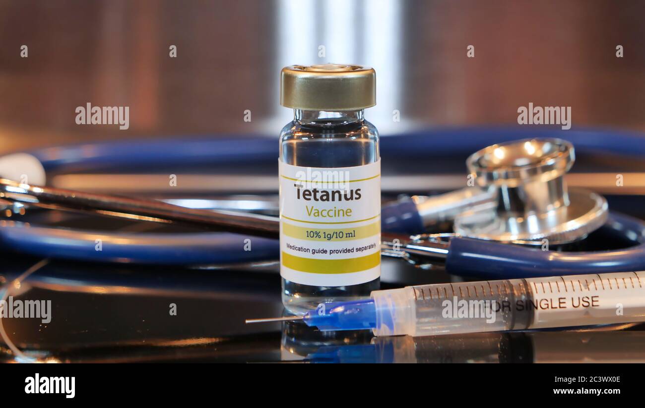 Vial of tetanus vaccine with syringe and stethoscope on a stainless ...