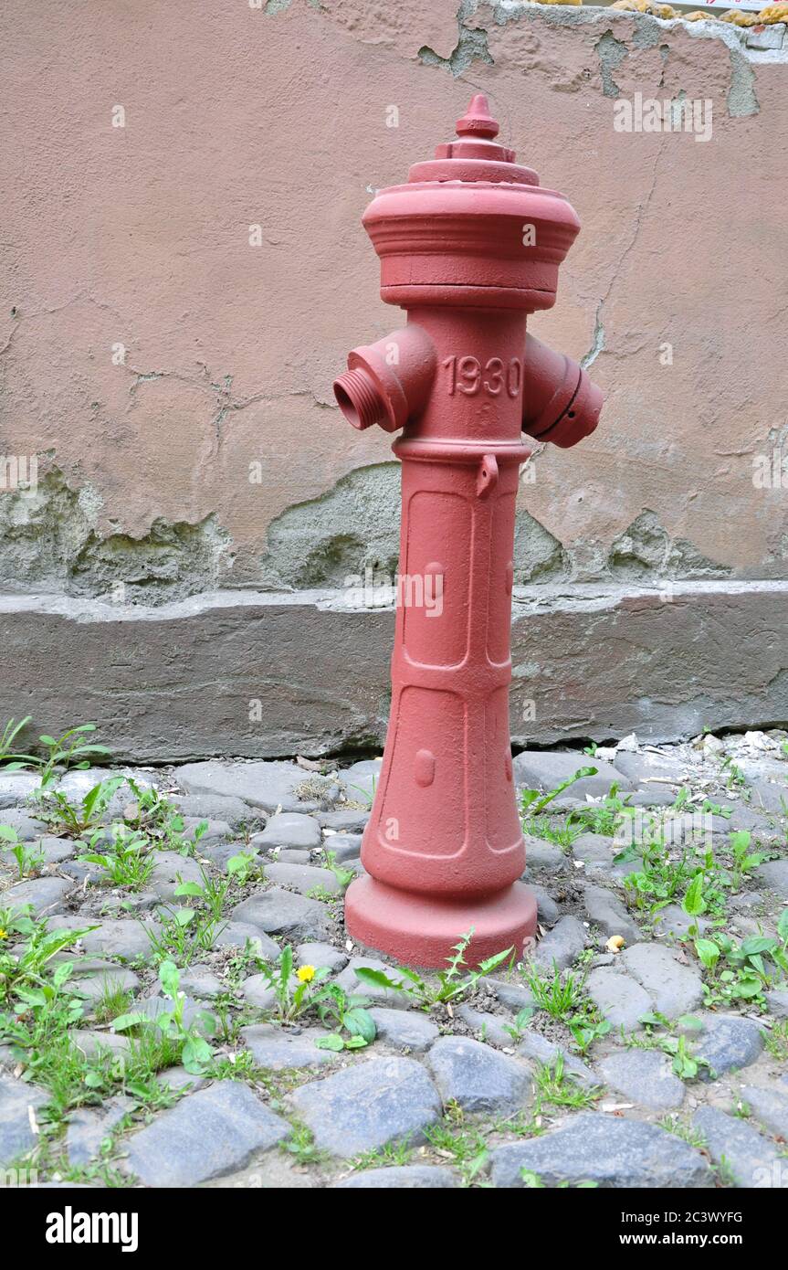 Retro hydrant. Red. The street is paved with old gray paving stones ...