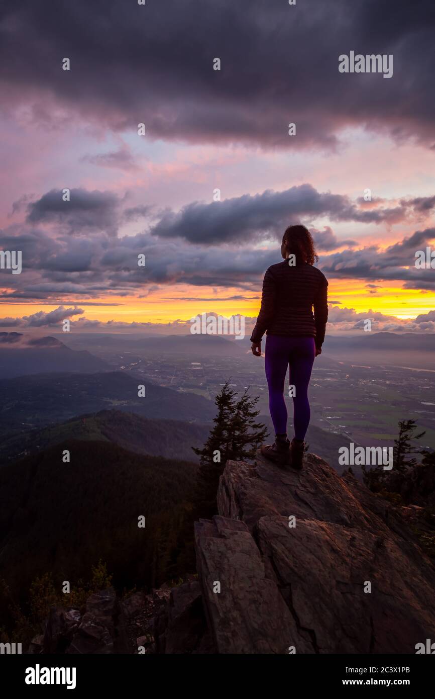 Adventurous Girl on top of a Rocky Mountain overlooking the beautiful ...