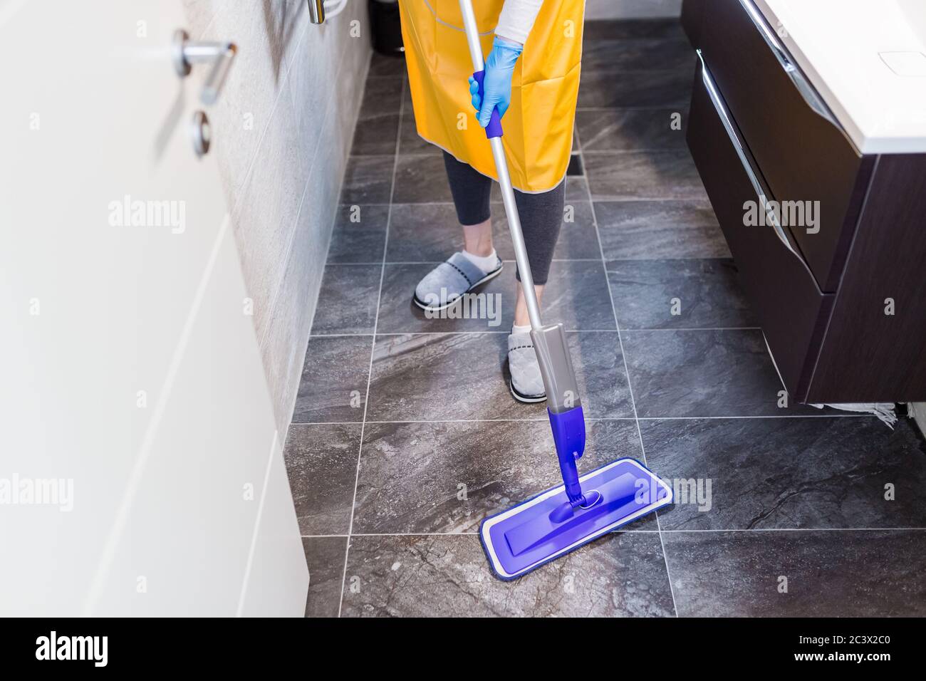 Maid doing chores at home by holding mopping stick. Coronavirus ...