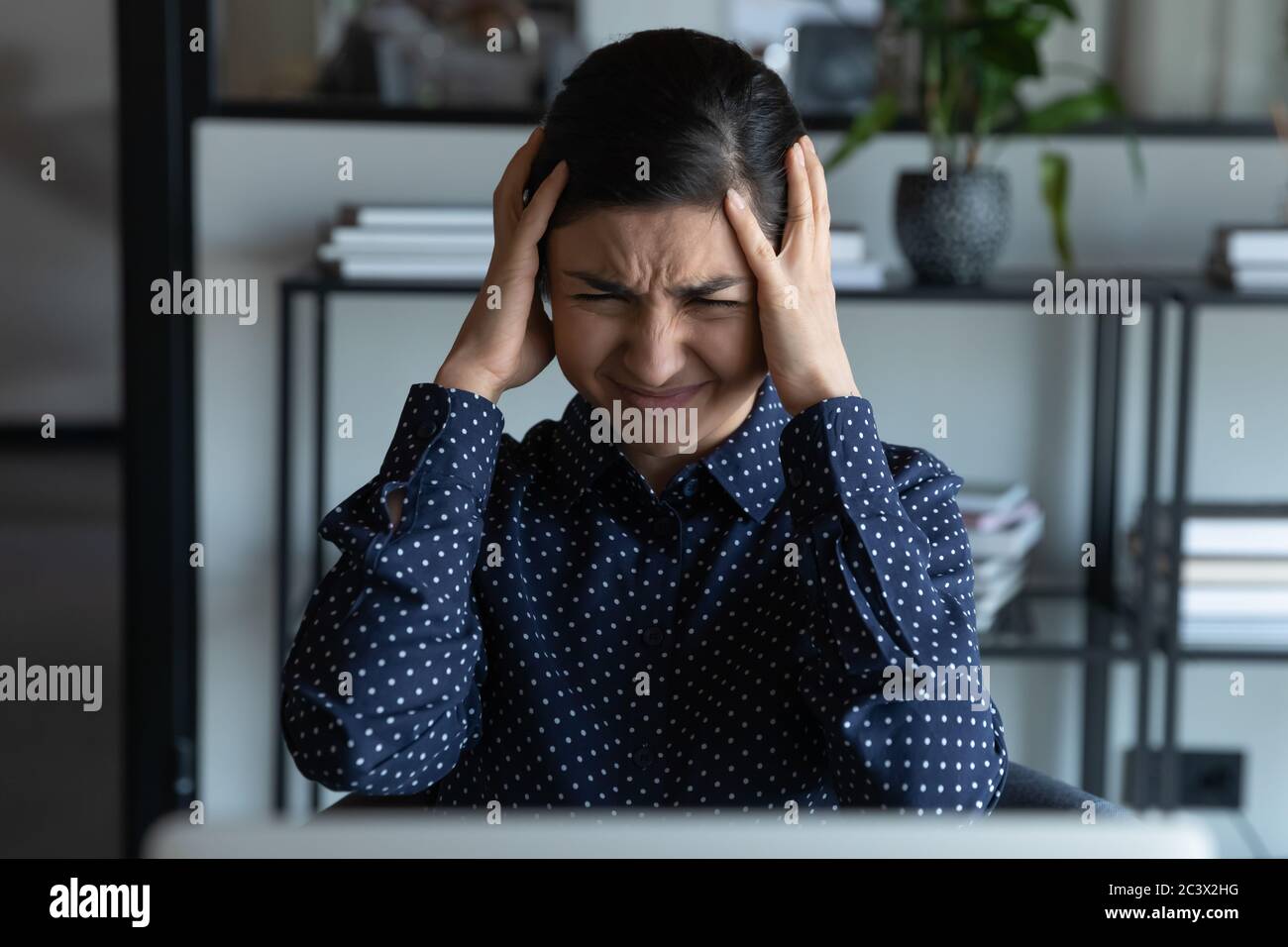 Indian employee suffers from strong headache feels overloaded at ...