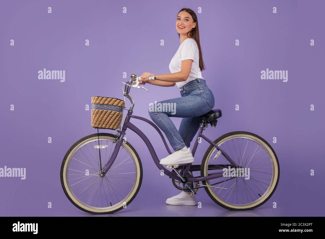 Beautiful woman riding her bike at studio, isolated Stock Photo - Alamy