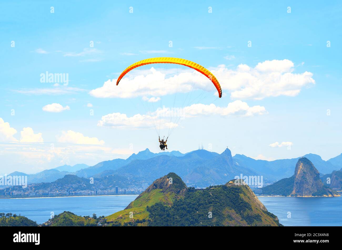A colorful parachute with skydiver on sunny blue sky background. Active ...