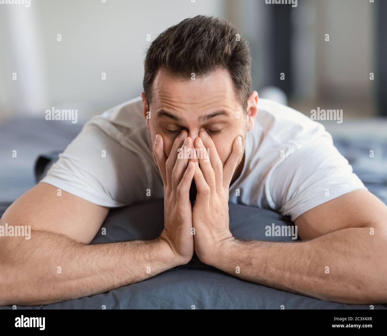 Sleepy Man Rubbing Eyes Waking Up Lying In Bed Indoor Stock Photo - Alamy