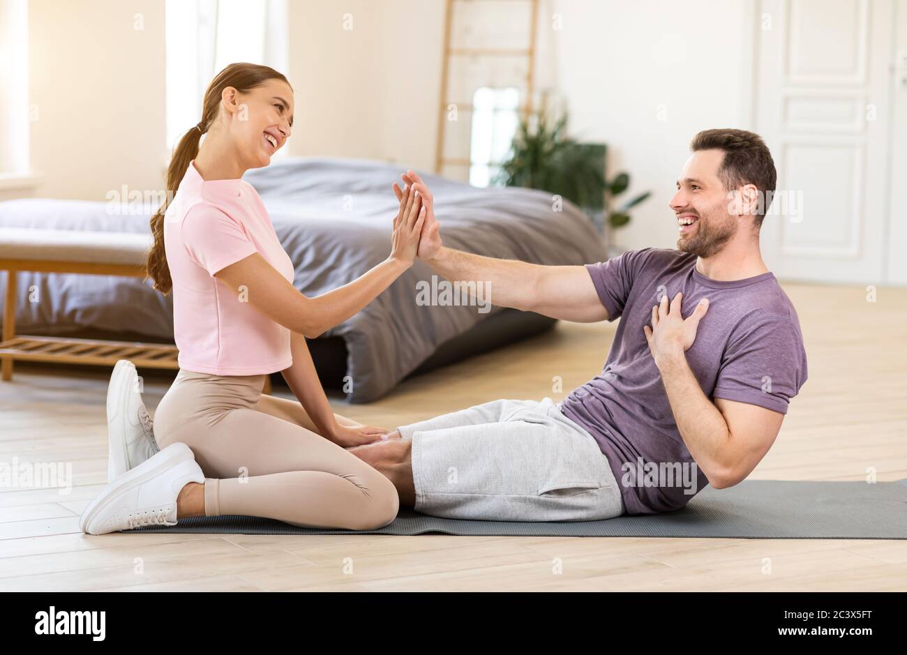 Couple Training Together Doing Abs And Giving High-Five Indoors Stock ...