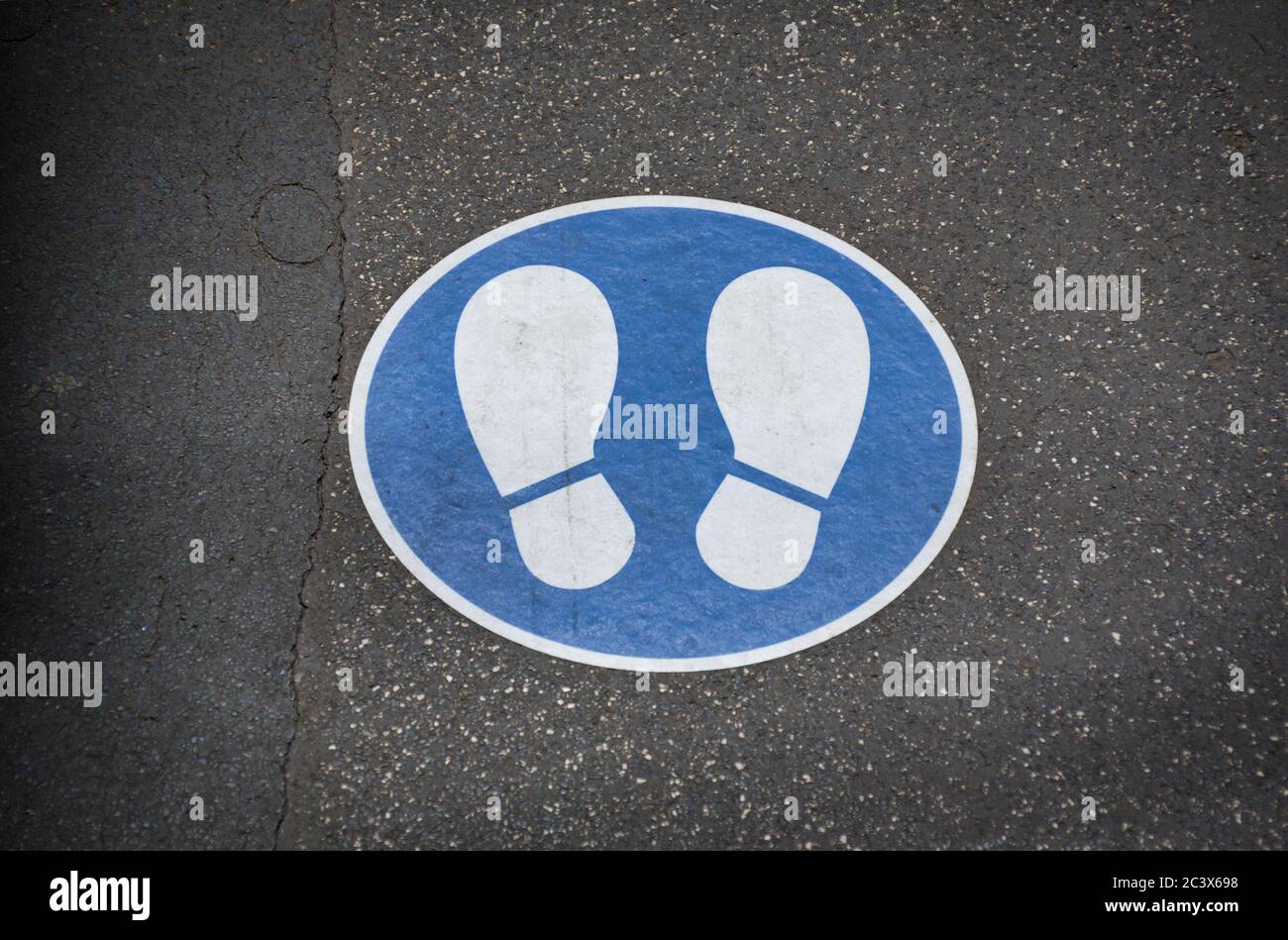 Safe social distancing blue and white feet mark isolated on the floor ...