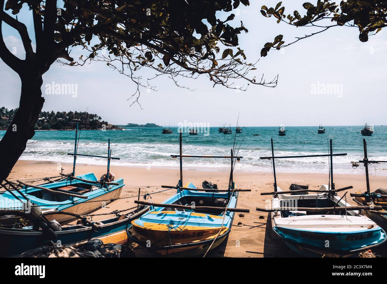 Idle fishing boats tied to the shore at a secluded beach in Sri Lanka ...