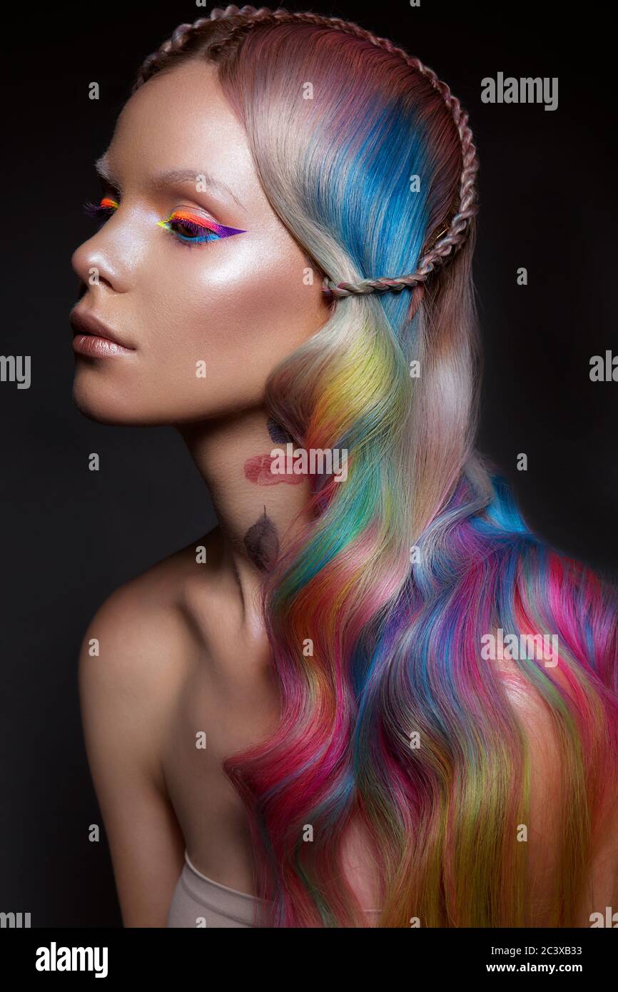 Beautiful girl with multi-colored hair and creative make-up and ...