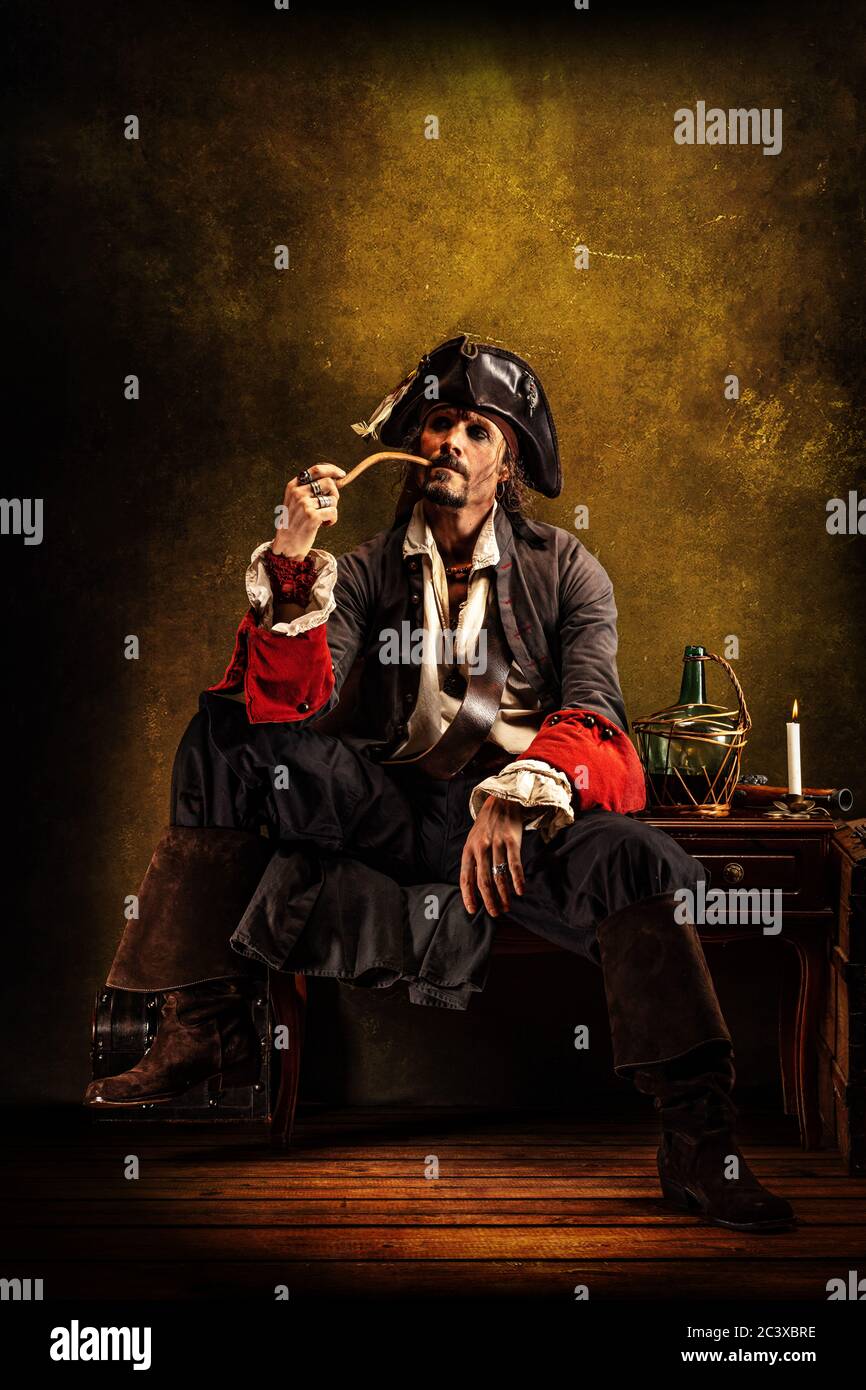 Portrait of a pirate smoking a pipe, sitting in a tavern Stock Photo ...