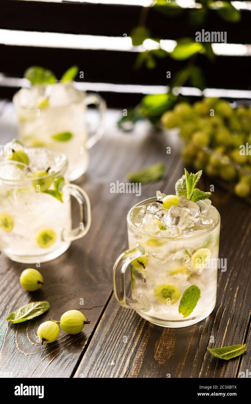 Cold summer drink with green gooseberries and mint, lemonade with ice ...