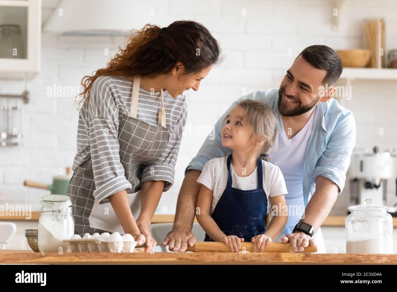 Mother and father teaching little daughter to cooking pastry Stock ...