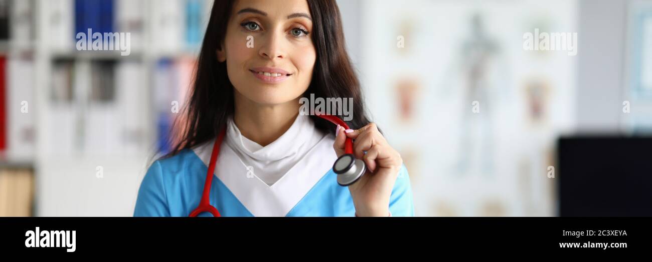 Beauty nurse in blue scrubs against clinic medical office background ...