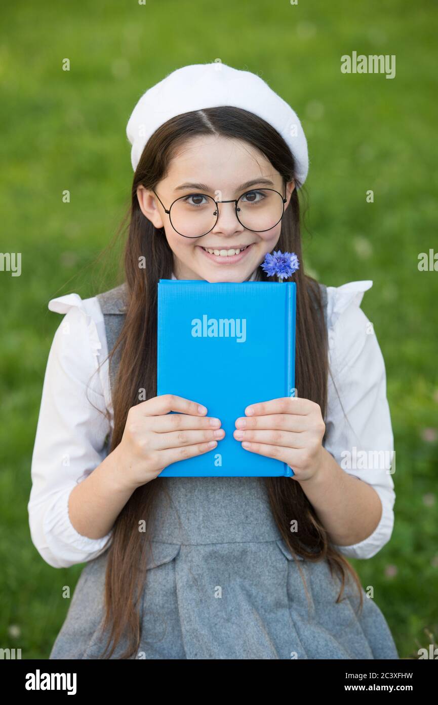 Reading helps you gain knowledge. Happy child hold book outdoors ...
