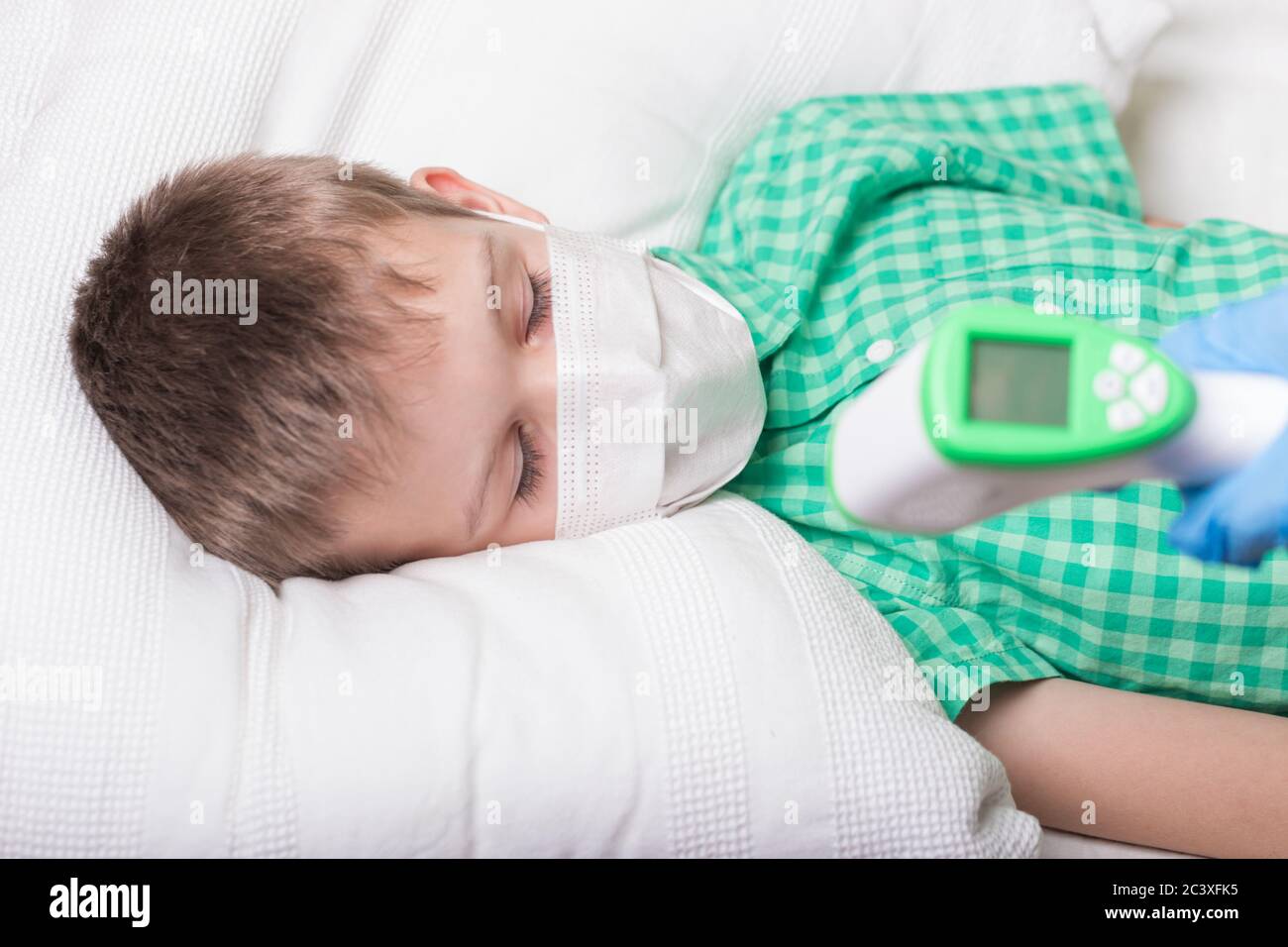 Sleeping boy measure the temperature with a thermometer Stock Photo - Alamy