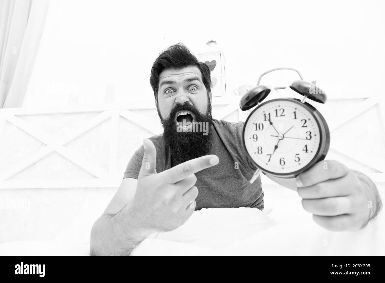 What time is it. Stressed man alarm clock. Sleepy man holding alarm ...