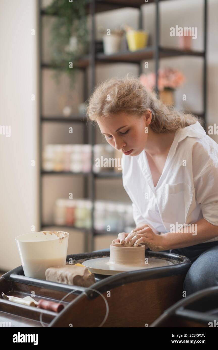 Potter makes the clay product with pottery modeling tools on the potter ...