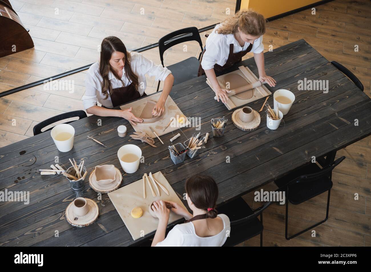 Beautiful young female artist girls creating handmade pottery in modern ...