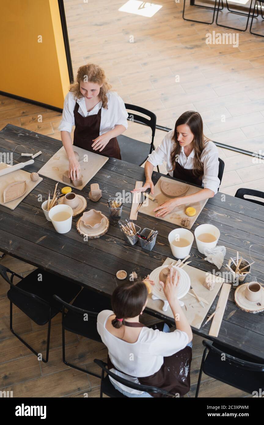 Beautiful young female artist girls creating handmade pottery in modern ...