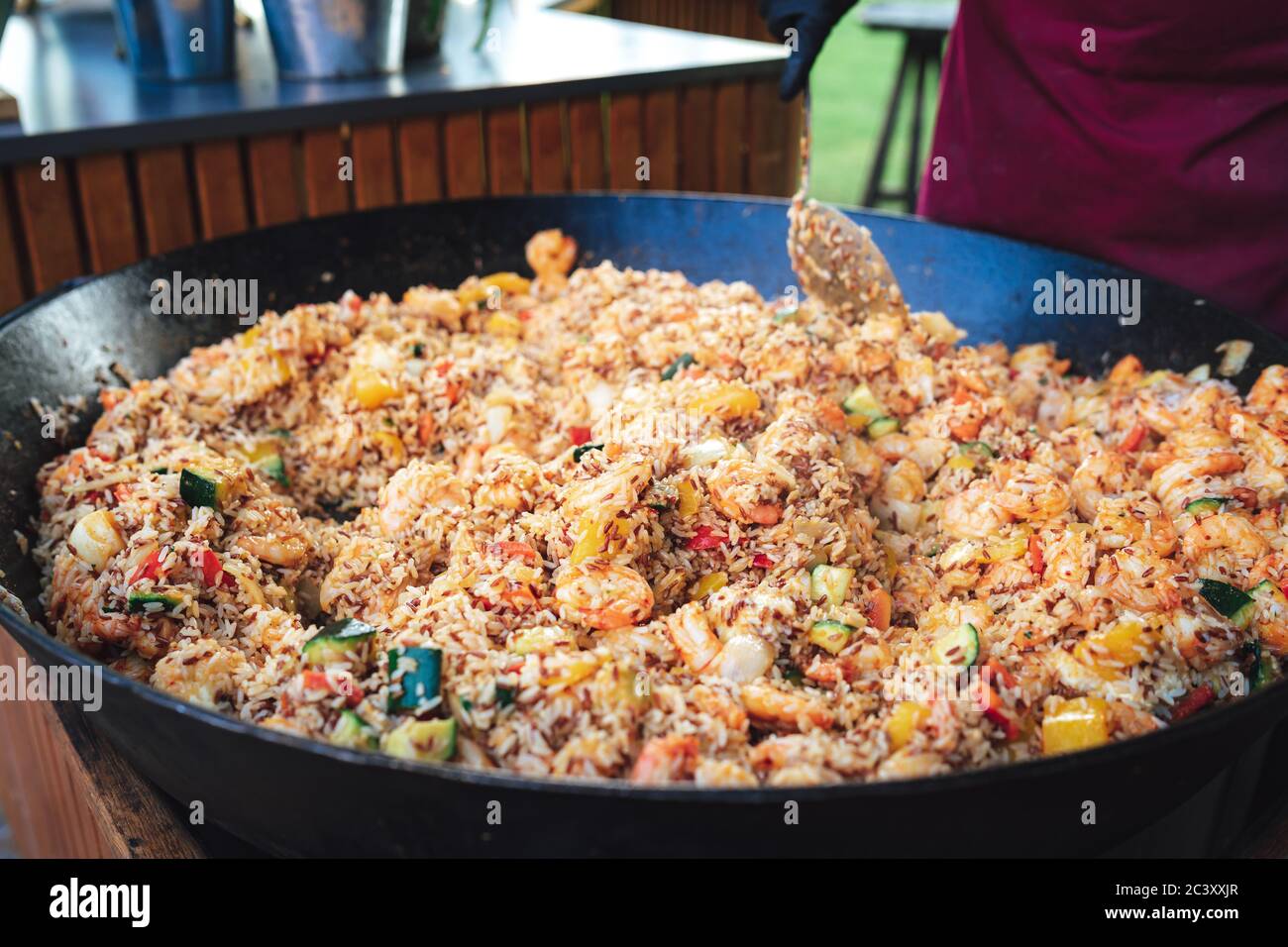 Big black pan full of meal. Mix of rice, vegetable and seafood ...