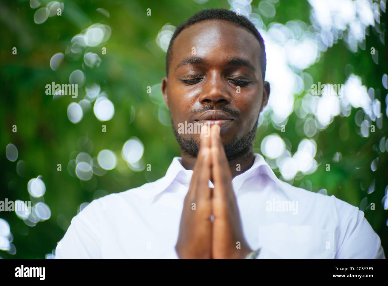 African man praying to god in the green nature Stock Photo - Alamy