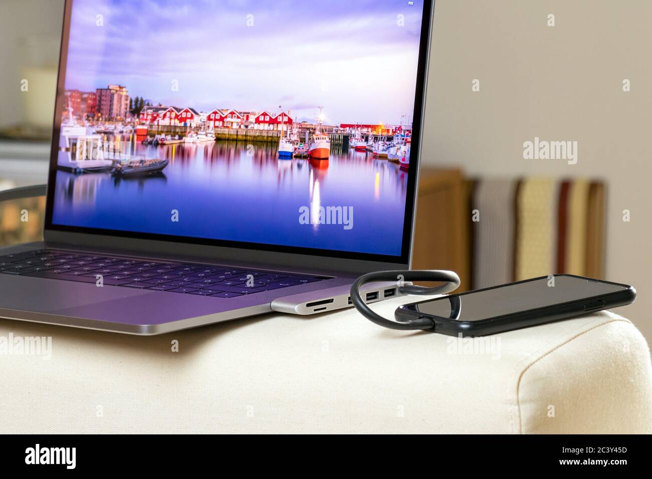 Smartphone is being charged connected to a hub adapter on a laptop ...