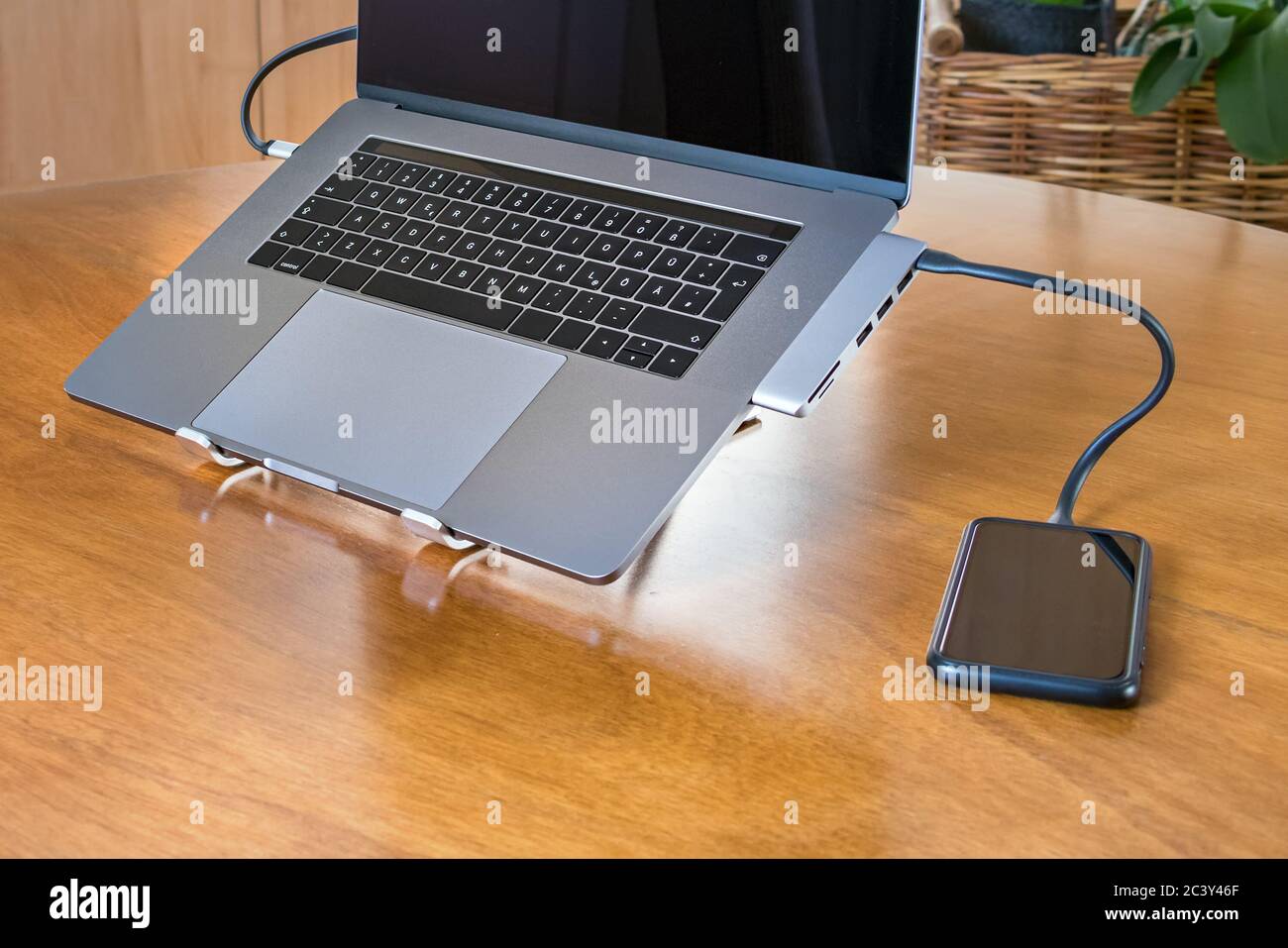 Smartphone is being charged connected to a hub adapter on a laptop ...