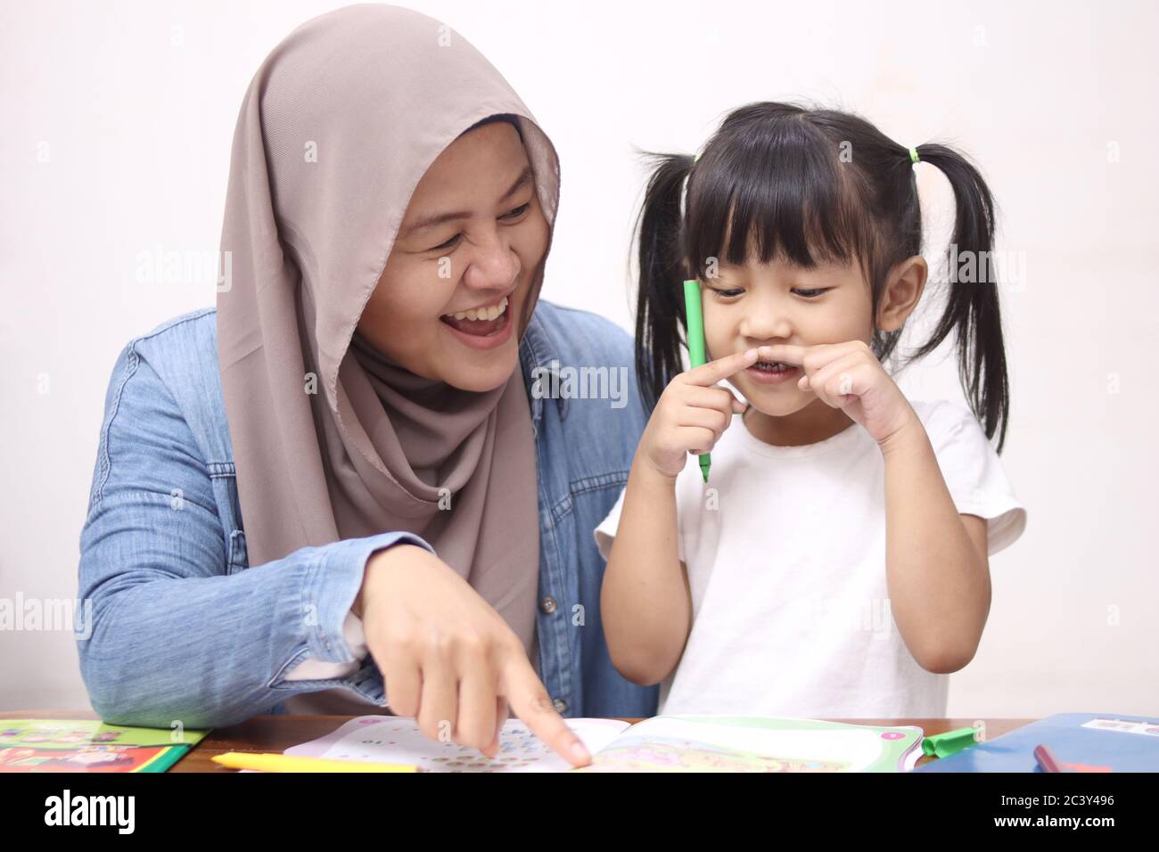 Asian muslim mother drawing with her daughter, single mom teaching baby ...