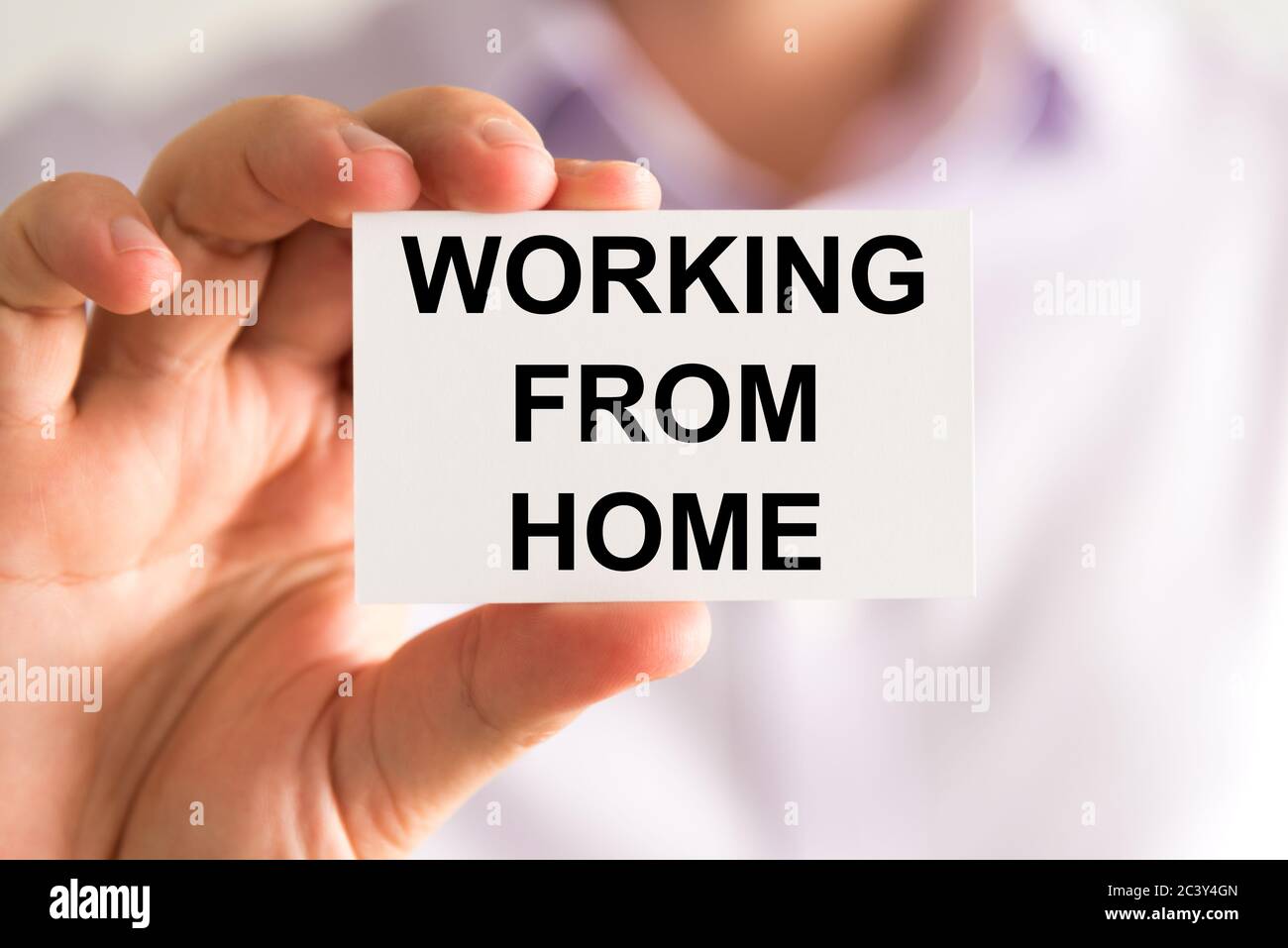 Closeup on businessman holding a card with text Working From Home ...