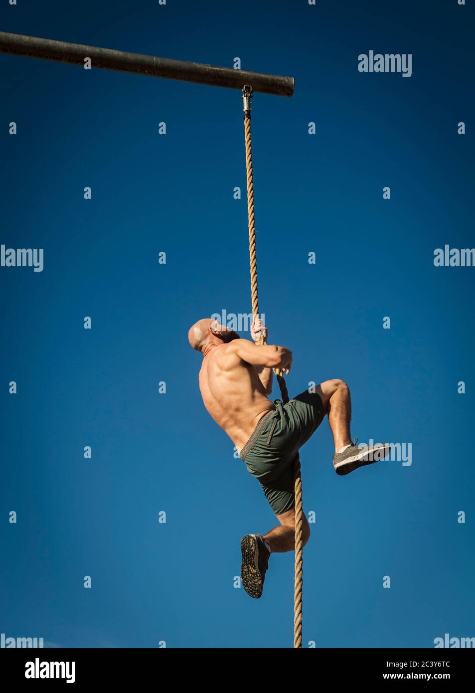 Man climbing on rope Stock Photo - Alamy