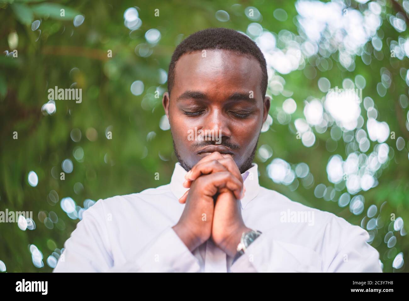 African man praying to god in the green nature Stock Photo - Alamy