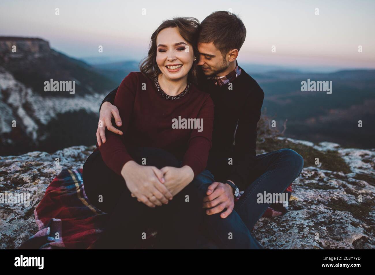 Ukraine, Crimea, Young couple sitting and hugging near canyon Stock ...