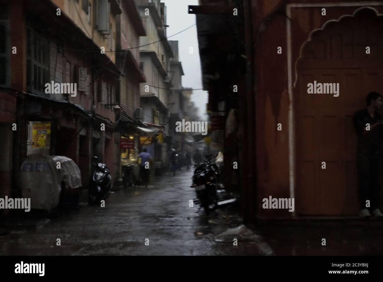 A view of a shopping alley from an intersection on a rainy day in ...
