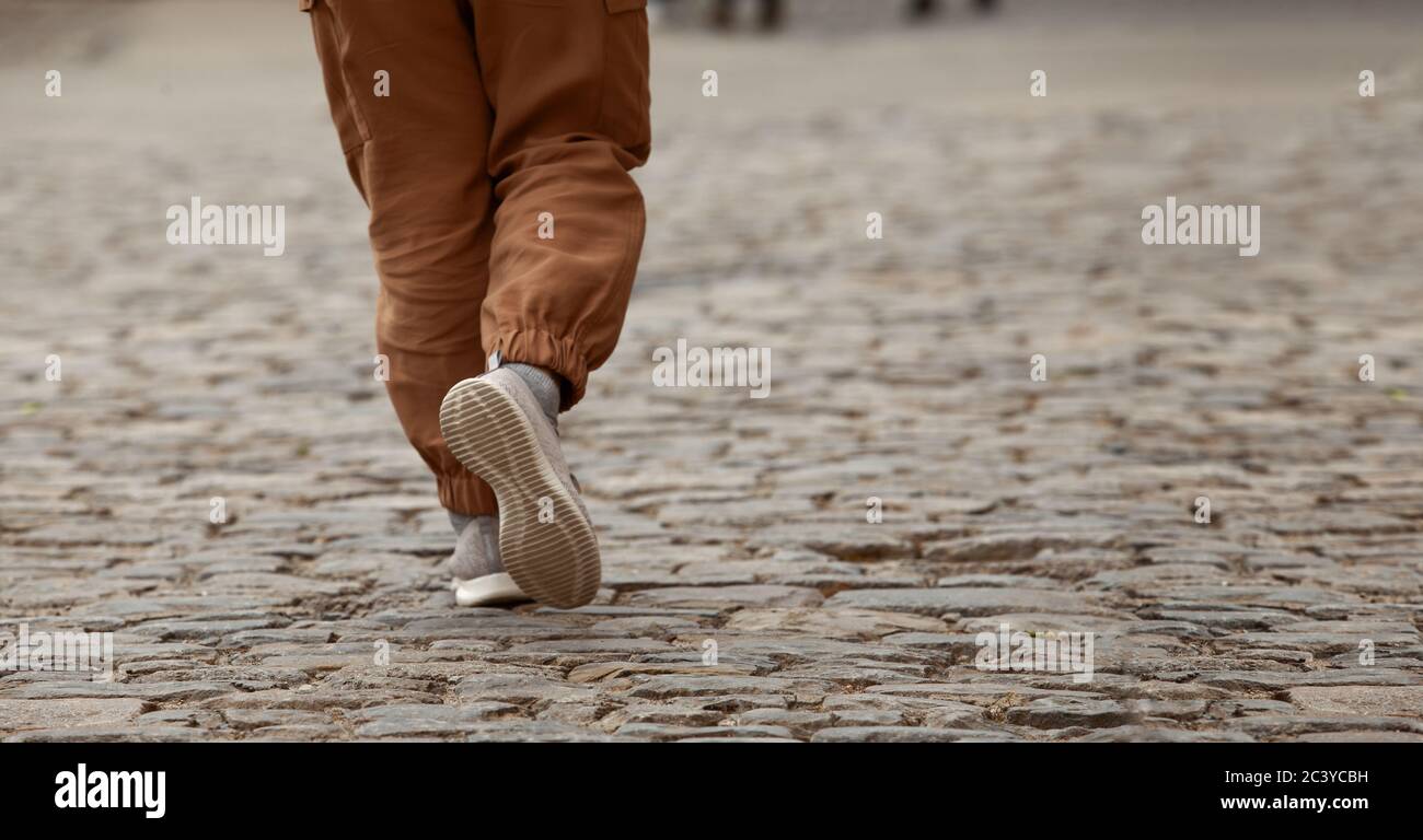 Legs of a tourist, leaving on the old paving stones Stock Photo - Alamy